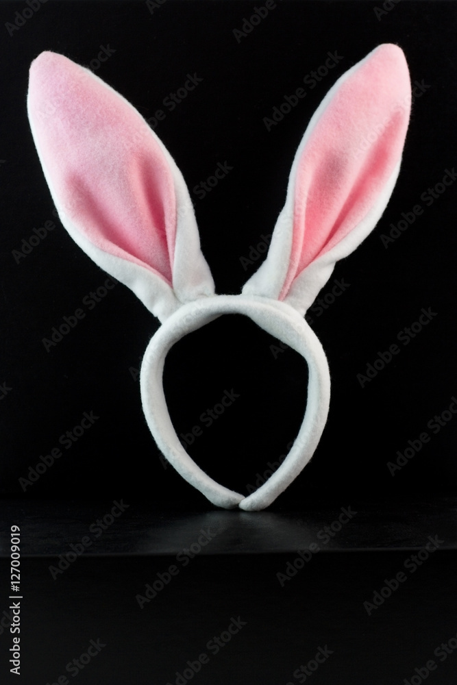 Pink and white Easter costume bunny ears on black background. Vertical ...