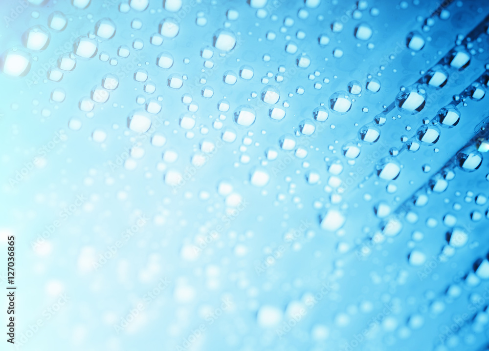 Blue water drops of on treat water-repellent surface in macro lens shot ...