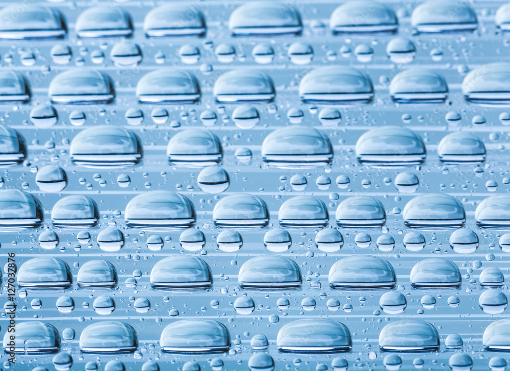 Blue water drops of on treat water-repellent surface in macro lens shot ...