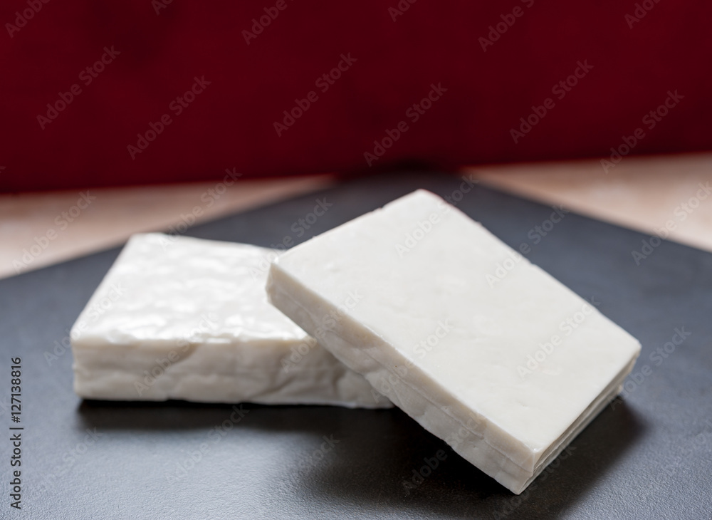 Buffalo paneer Indian cheese on black slate cutting chopping board ...