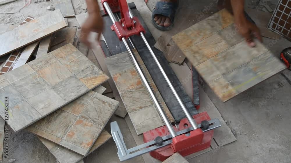 Industrial tiler builder worker working with floor tile cutting ...