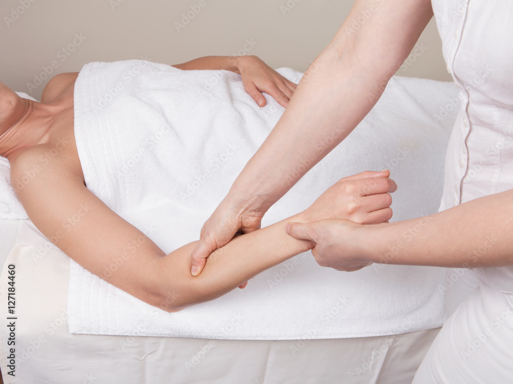 Therapist doing therapeutic deep tissue massage on muscles of a woman's ...