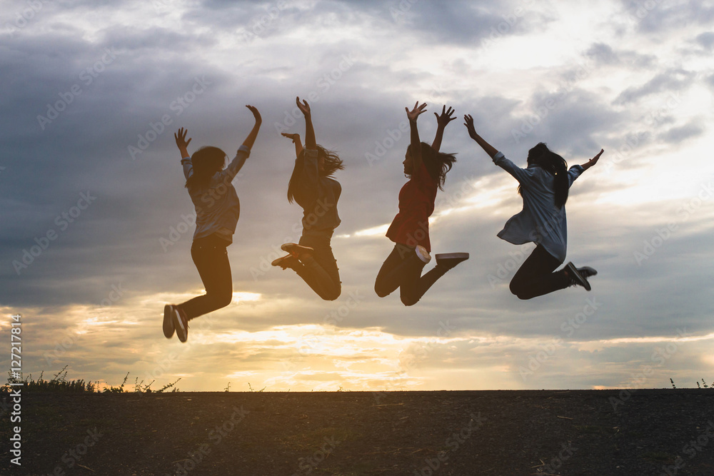 Silhouette jumping team. Friends jumping on the beach under sunset ...