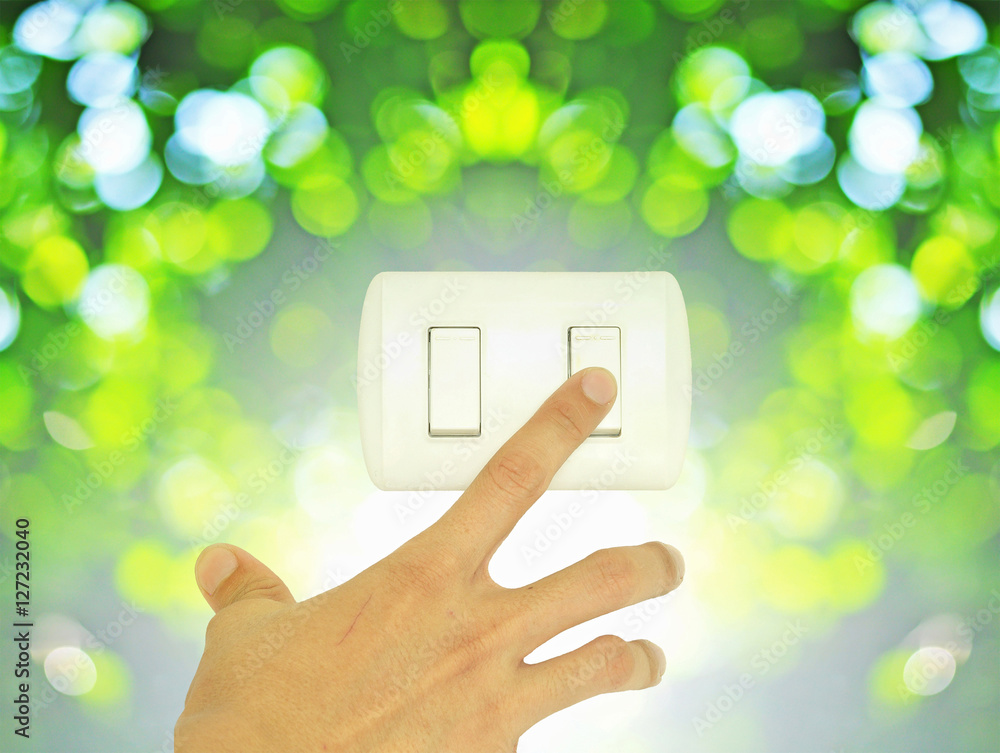 Man hand turn off light switch on green nature bokeh background, Eco ...
