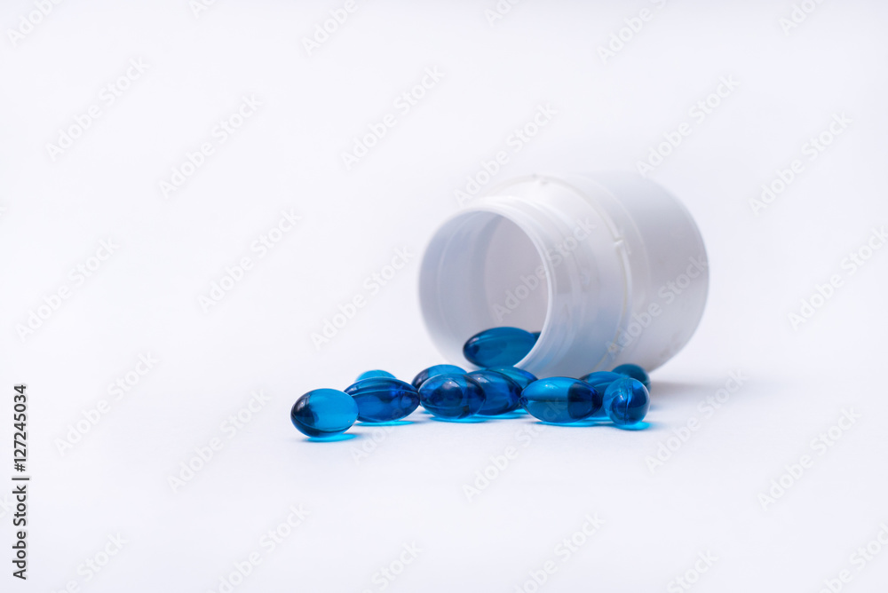 Blue pills spill out from bottle isolated on white background. Stock ...