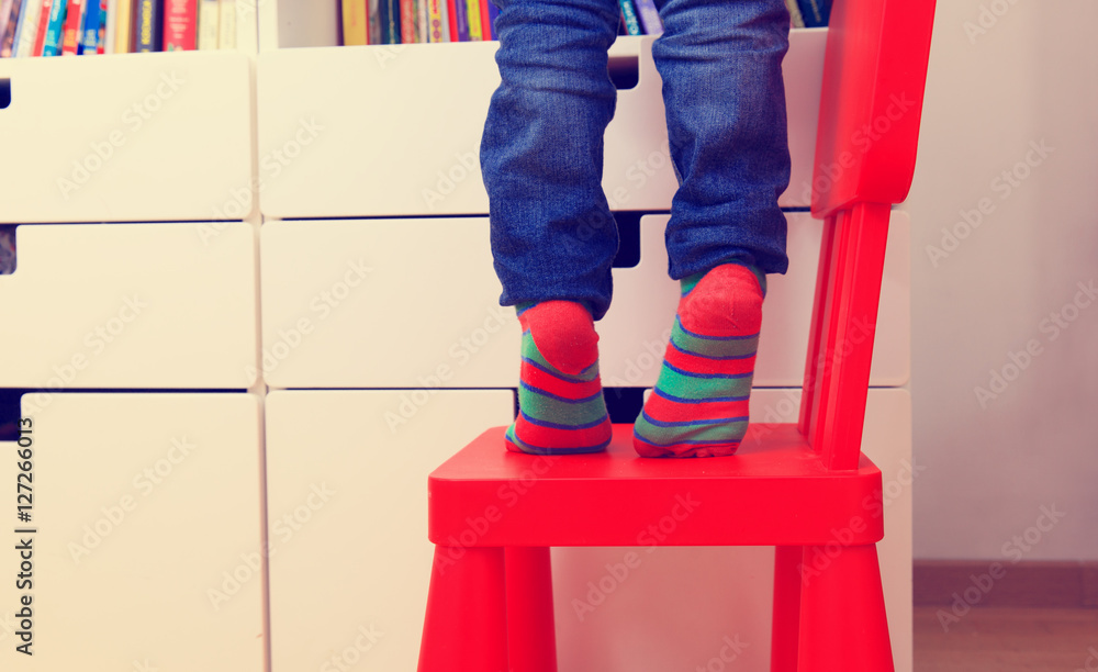 kids safety concept- child climbing on baby chair Stock Photo | Adobe Stock