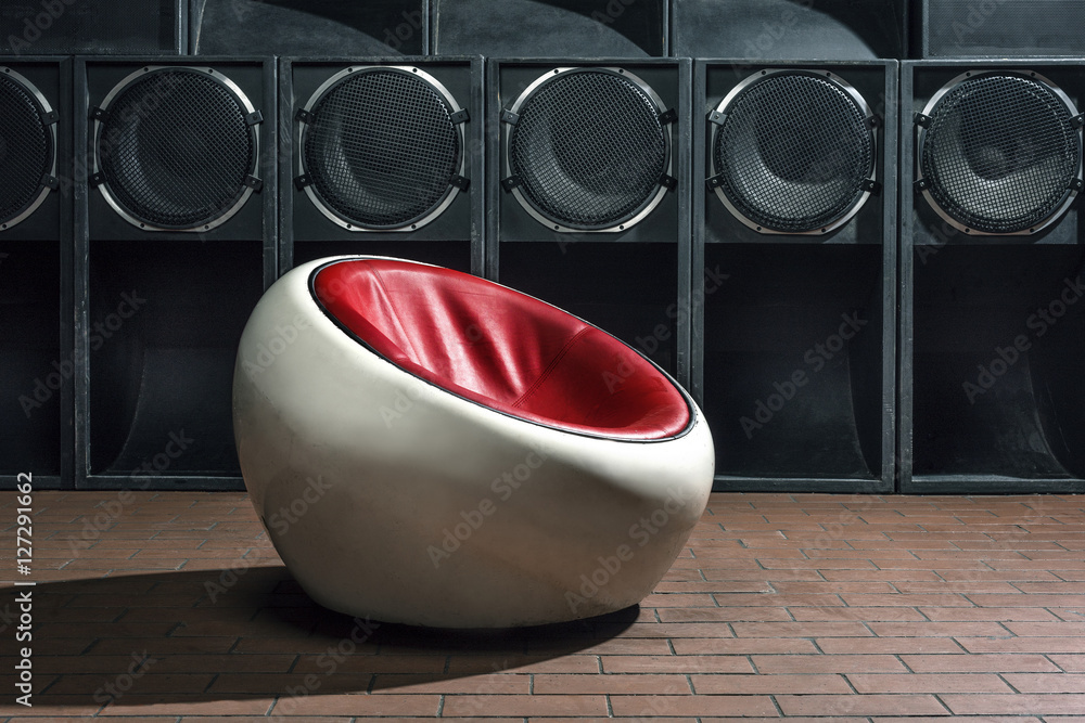 Old round plastic chair in seventies style with red leather in front of ...