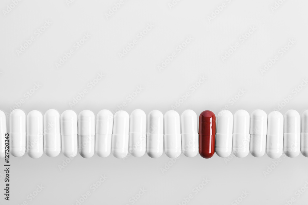 White capsules and one red in line Stock Photo | Adobe Stock