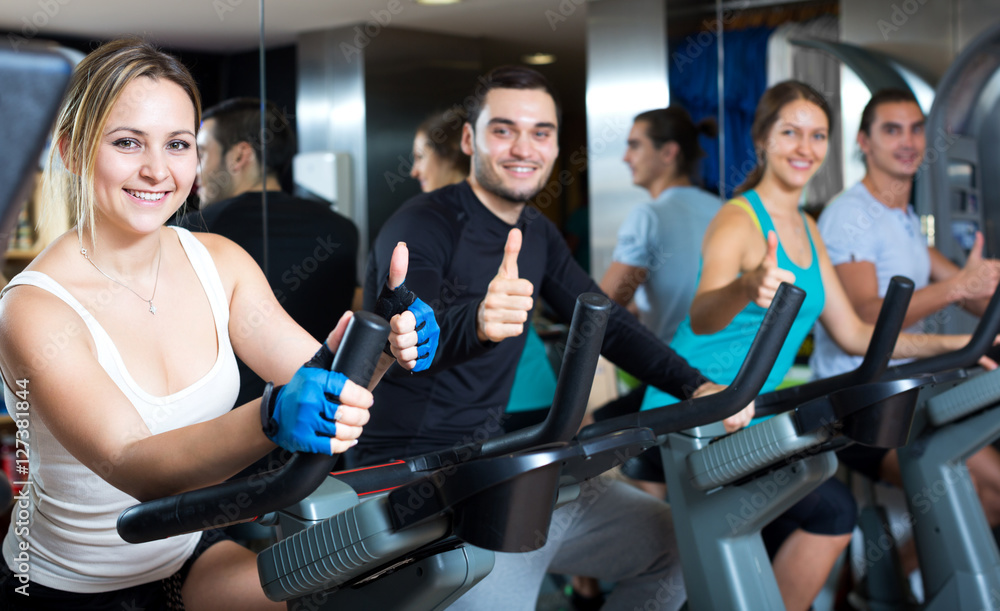 Active adults riding stationary bicycles Stock Photo | Adobe Stock