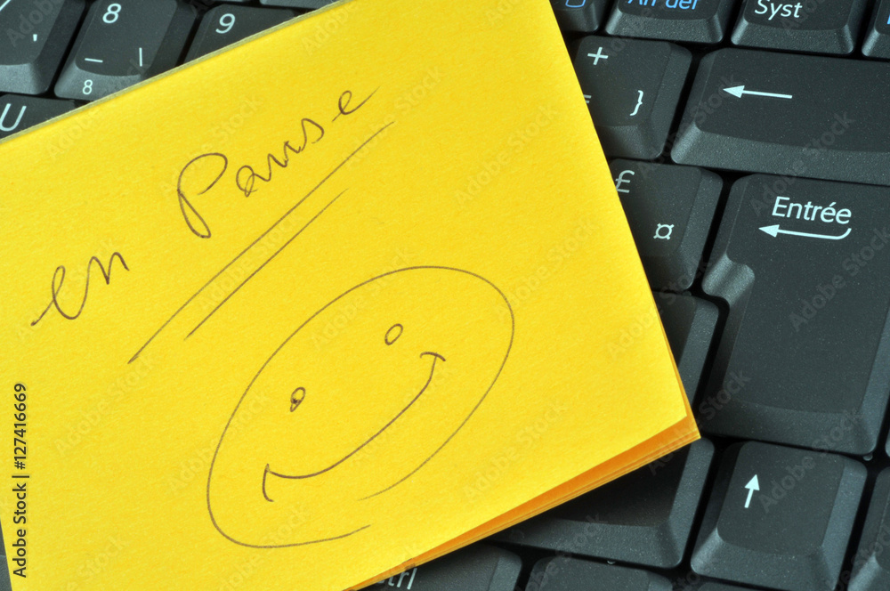En pause écrit sur un morceau de papier posé sur un clavier d ...