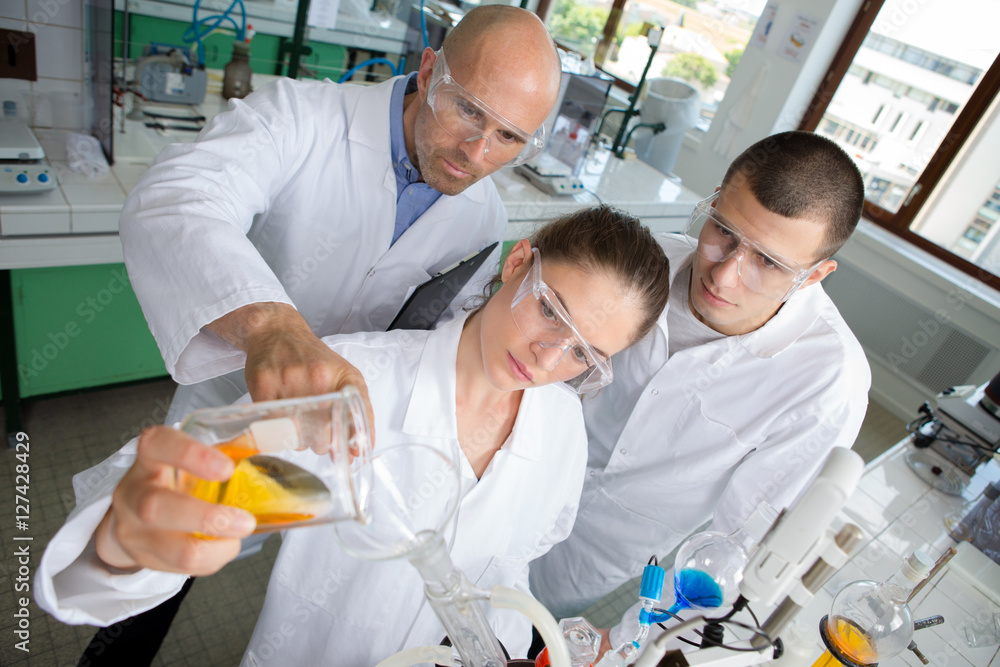 young life science professional pipetting solution into the glass ...