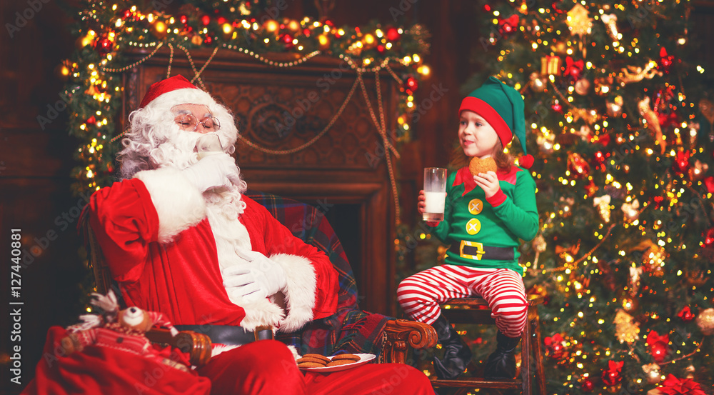 Santa Claus and elf child in Christmas drinking milk and eating Stock ...