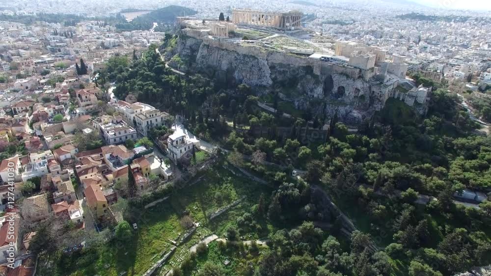 Aerial drone bird-eye view moving up for flight around the Acropolis of Athens ancient citadel ...