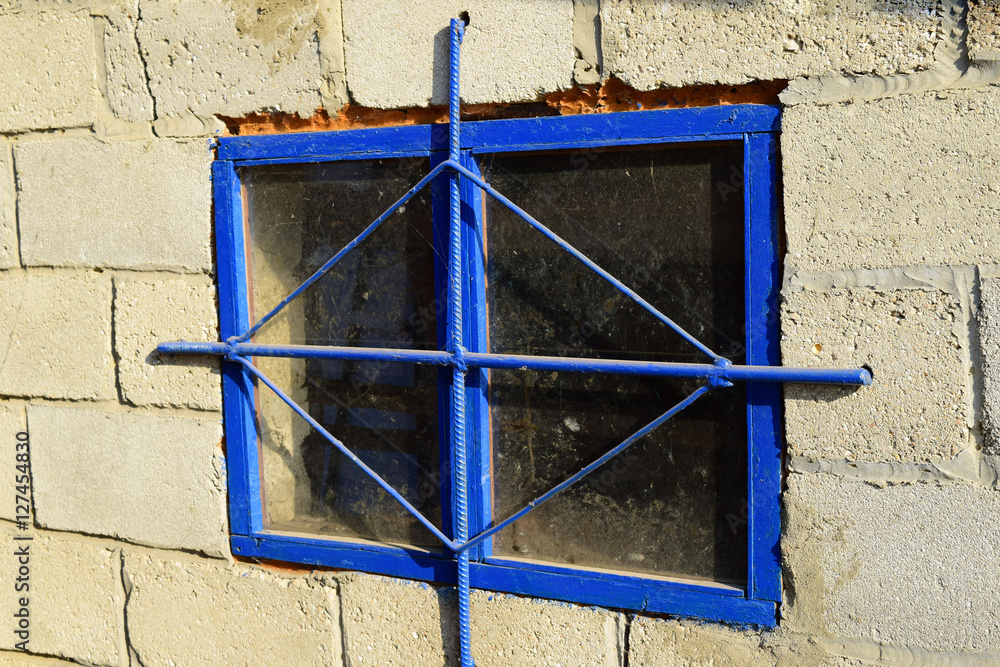 The blue box in the wall with the lattice. Protect windows grating ...
