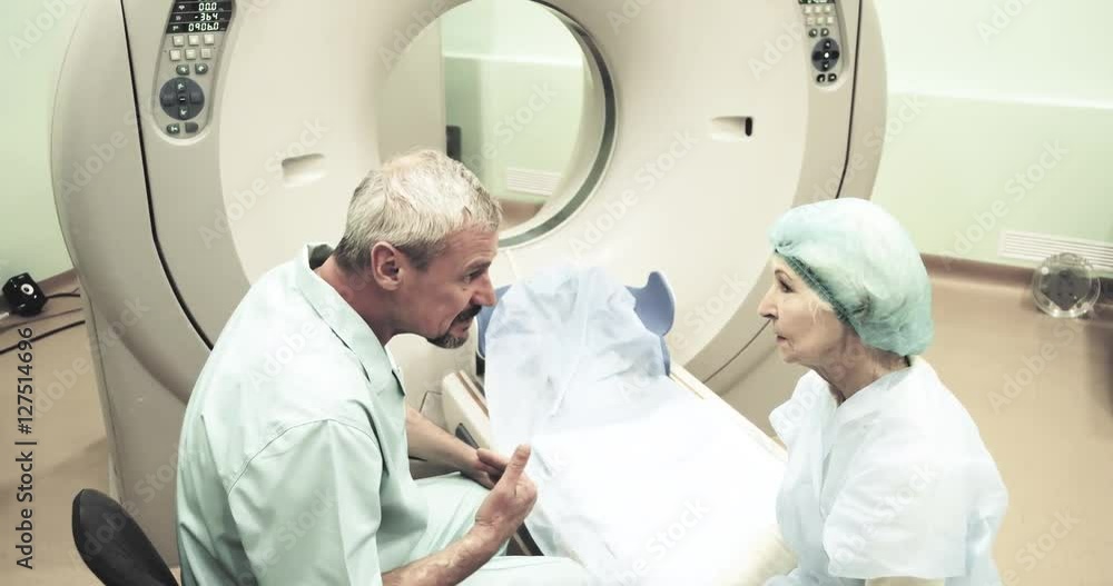 Doctor talks calms female patient before CT MRI scanning 4k video. Elderly woman listens to ...