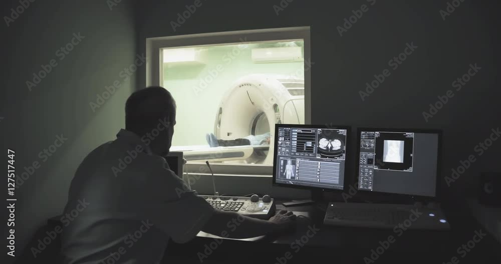 Doctor looking at computer screen while patient in CT MRI scanner 4k ...