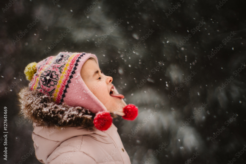 girl catching snow on tongue Stock Photo | Adobe Stock
