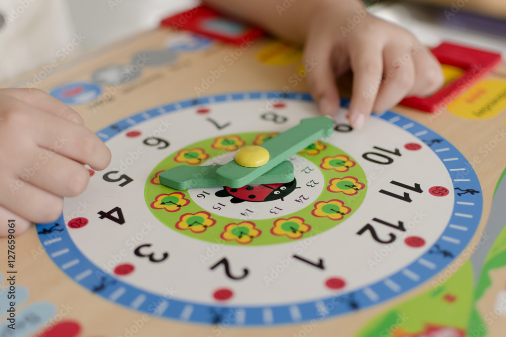 Little kid learning time with clock toy of Montessori. Stock Photo ...