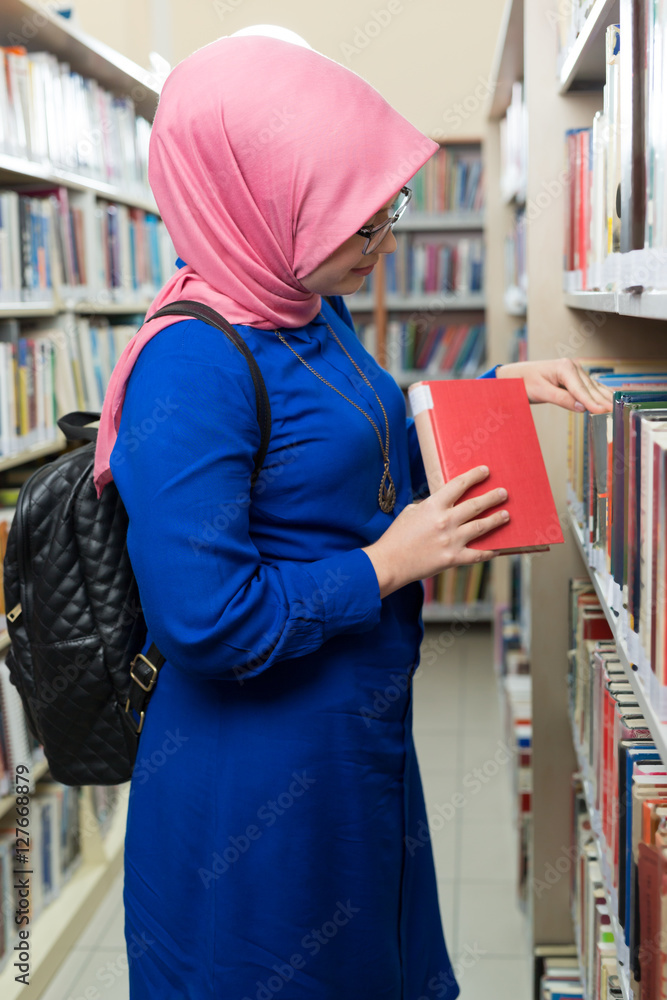 Muslim woman with a book at the library. Woman with hijab in lib Stock ...