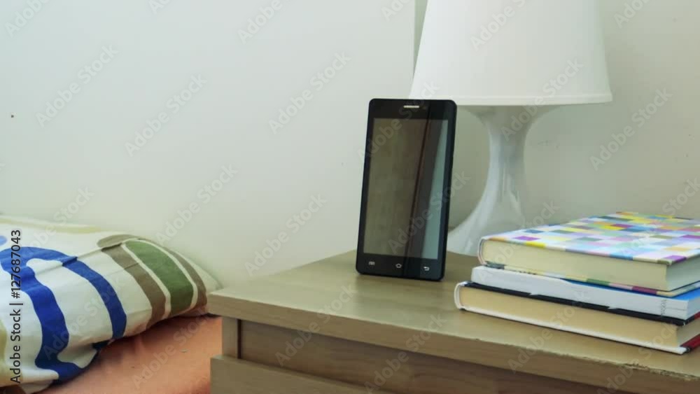 smartphone on bedside table next to the bed in bedroom - books Stock ...