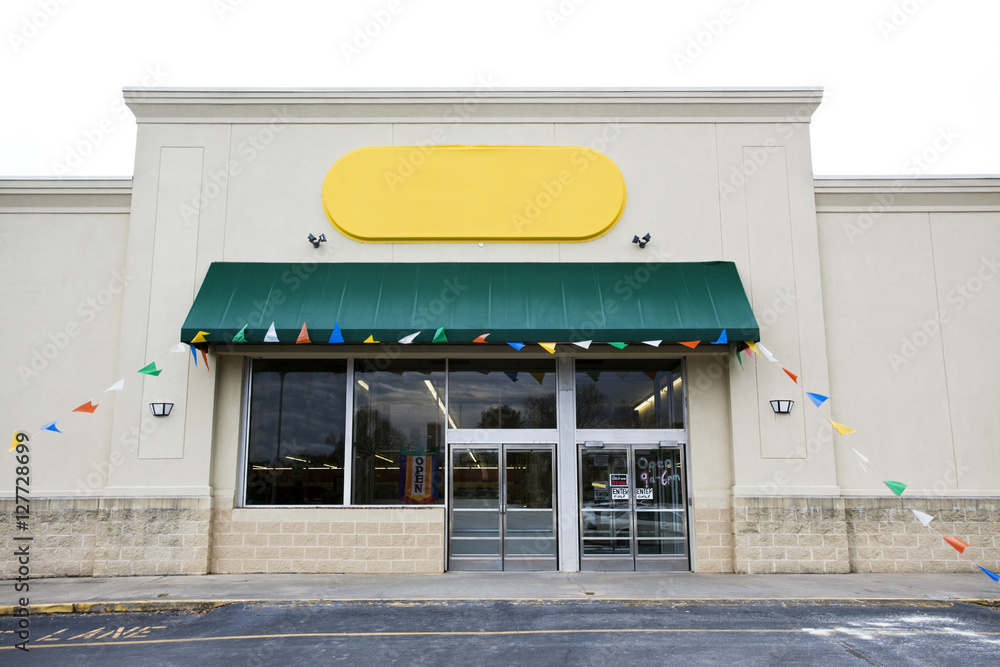 Storefront grand opening with blank yellow sign and banner flags ...