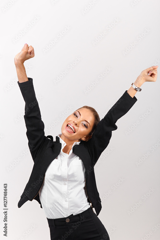 A portrait of a happy young woman with her hands up over white ...