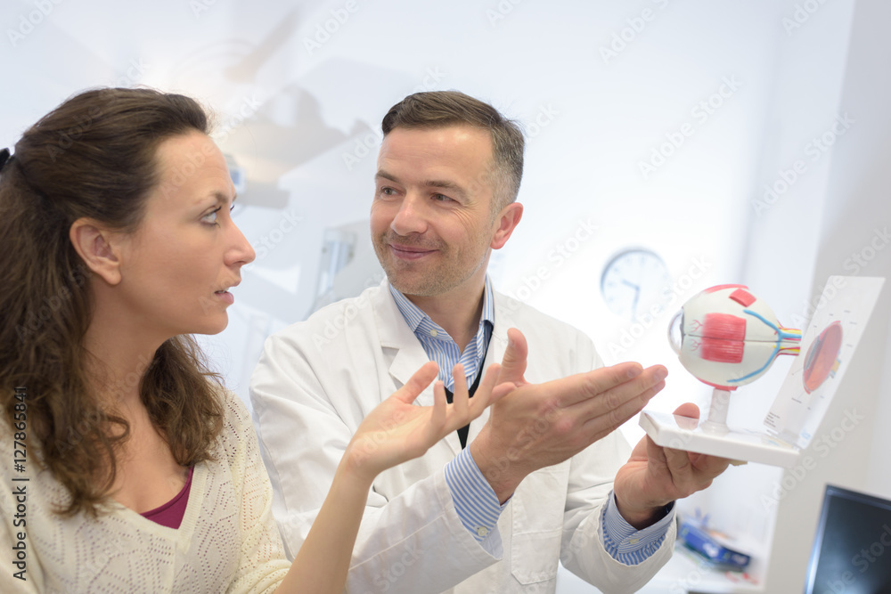 Doctor showing model of the eye to patient Stock Photo | Adobe Stock