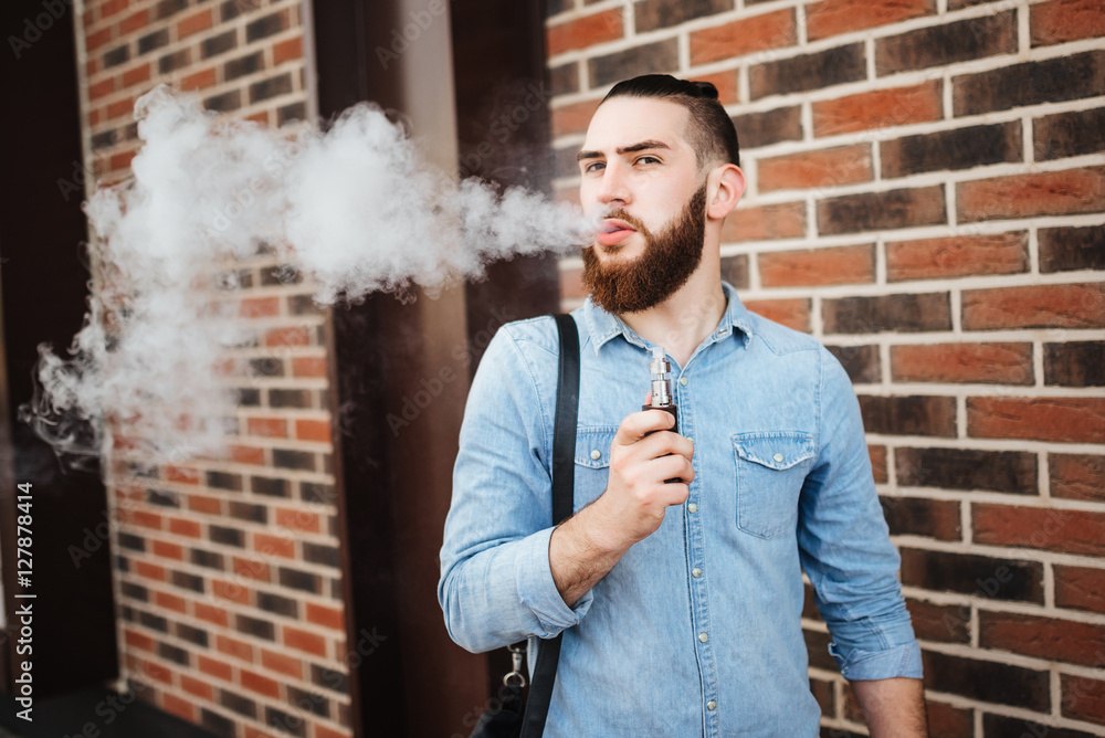 Vaping. Casual men with beard vaping an electronic cigarette. Vaping ...