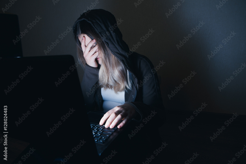 sad and scared female teenager with tablet computer and laptop ...