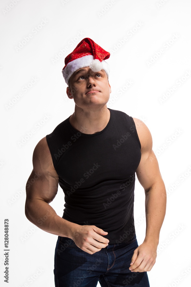 athlete bodybuilder posing with a beard and a cap of Santa Claus on a ...