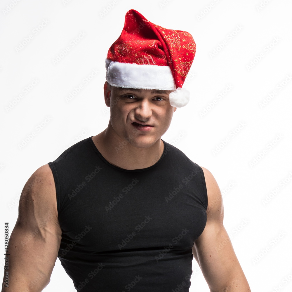 athlete bodybuilder posing with a beard and a cap of Santa Claus on a ...