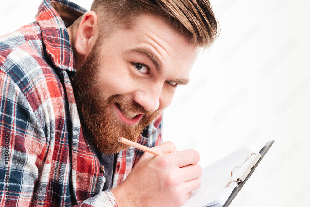 Man making funny face while writing on clipboard Stock Photo | Adobe Stock