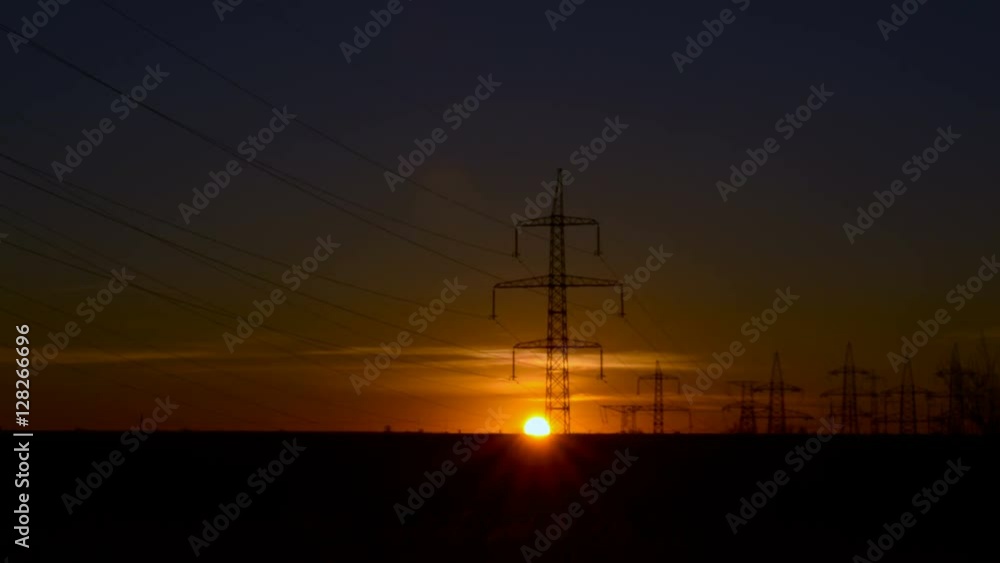 Sunset on the background of power lines. High-voltage power lines at ...