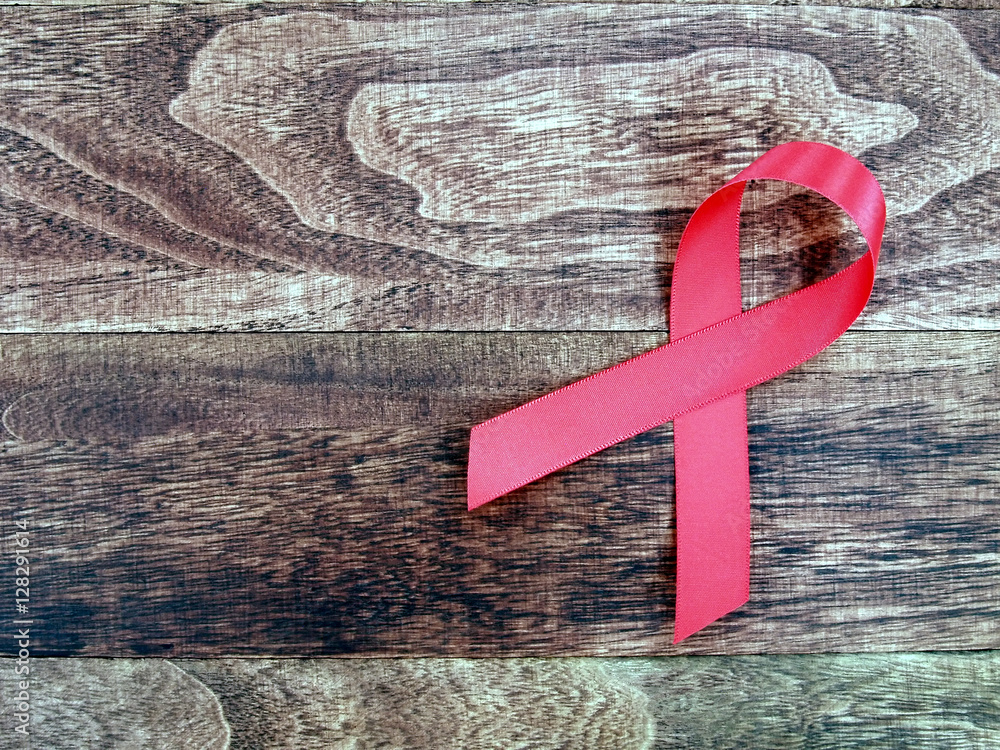 red aids ribbon on brown wooden floor, World AIDS Day symbol, copy ...