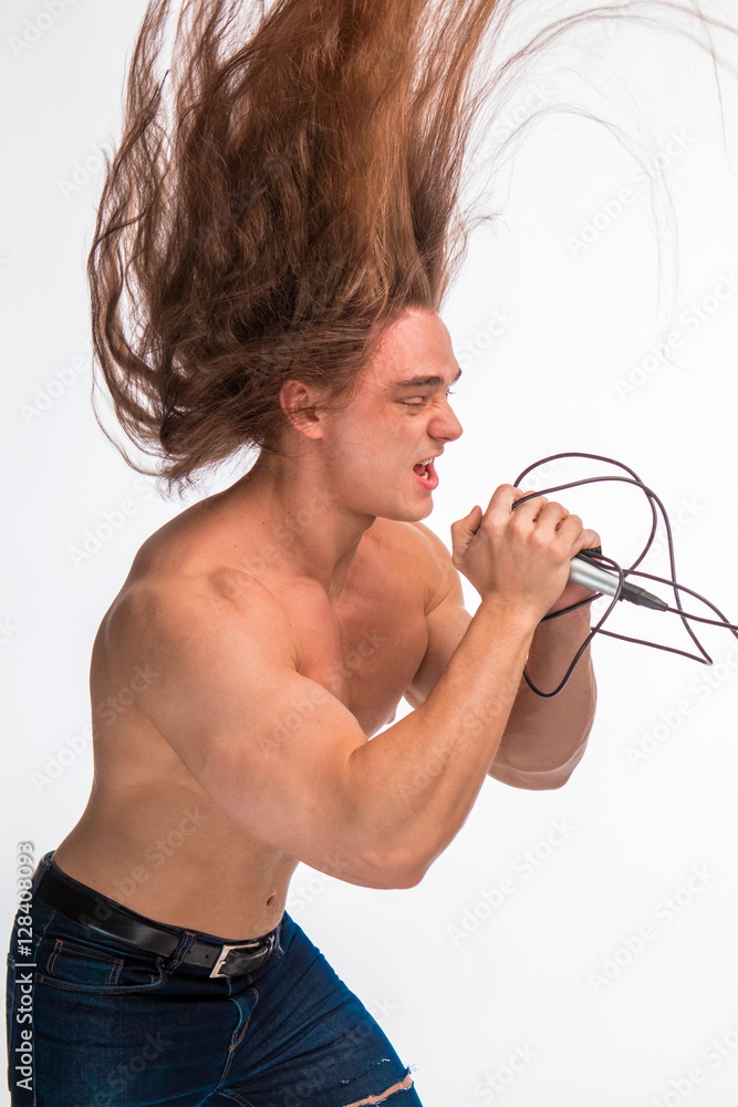 singer bodybuilder shirtless with long hair with a microphone on a ...