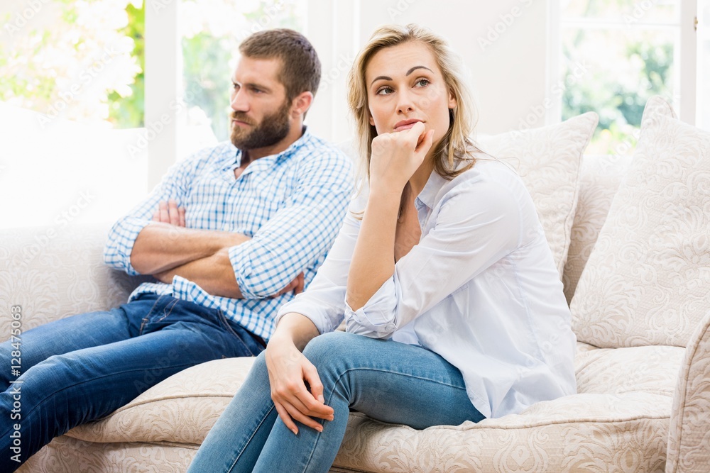 Young couple ignoring each other in living room Photos | Adobe Stock