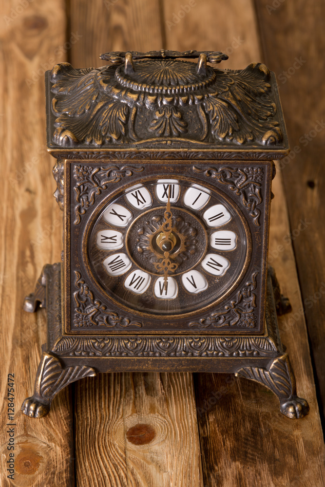 Vintage bronze clock on a wooden table Stock Photo | Adobe Stock
