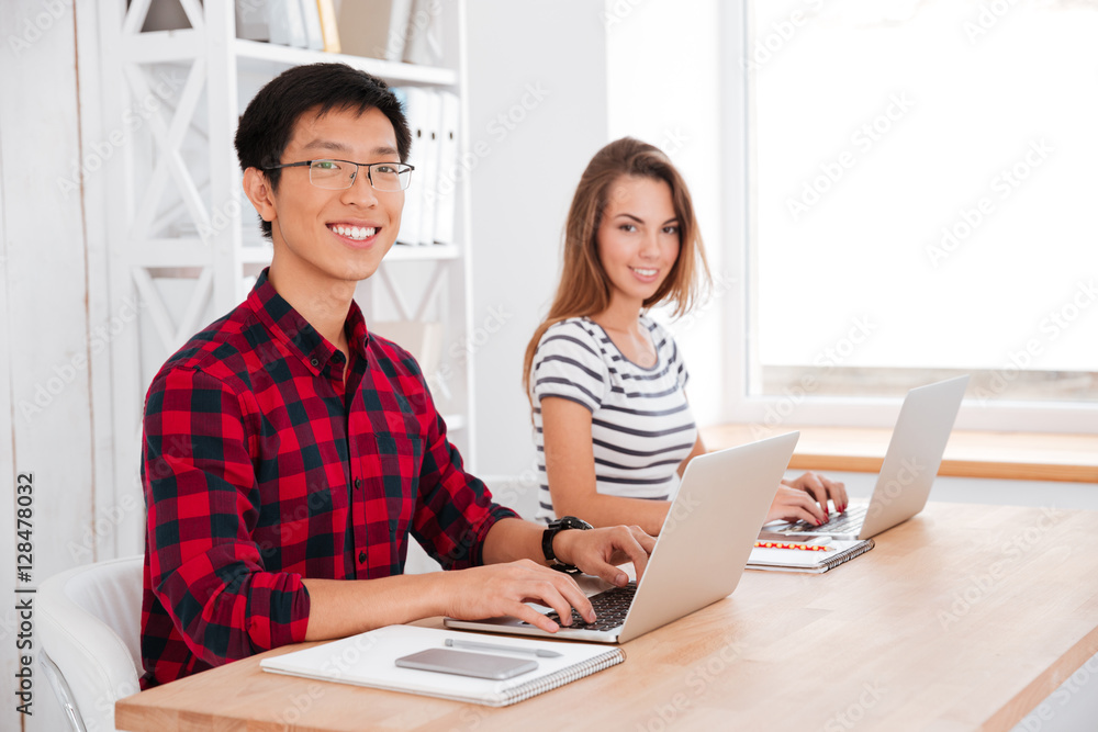 Emotional students working on their laptops in a classroom Stock Photo ...