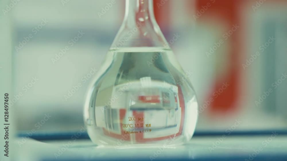 Chemical flask with a clear liquid on the table. Chemical Laboratory ...