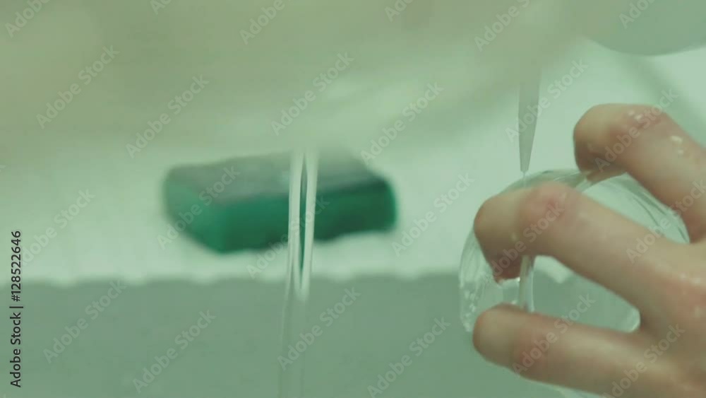 Slow motion: Close-up: washing the glass beaker. Chemical vessels ...