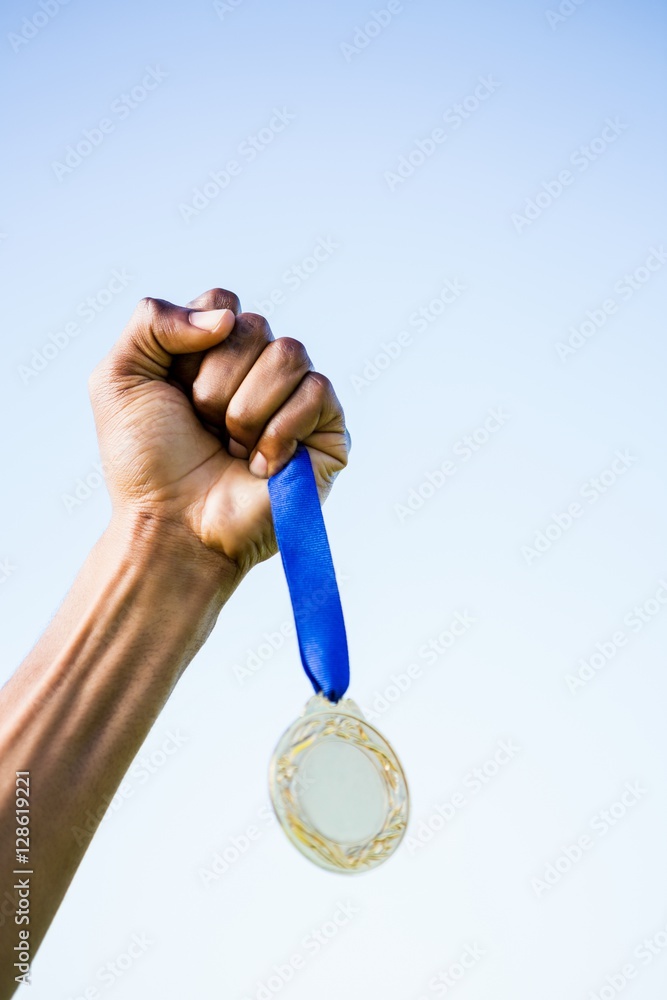Athlete hand holding gold medal after victory Stock Photo | Adobe Stock
