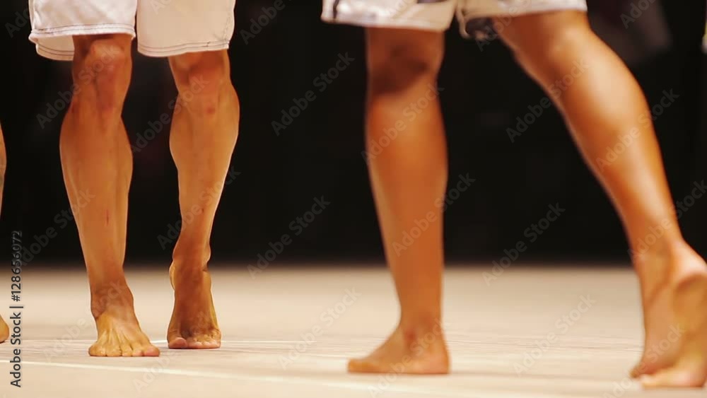 Legs of male fitness models posing at bodybuilding competition, healthy ...