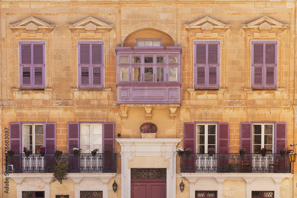 Front view of a medieval Mediterranean style building with purple ...