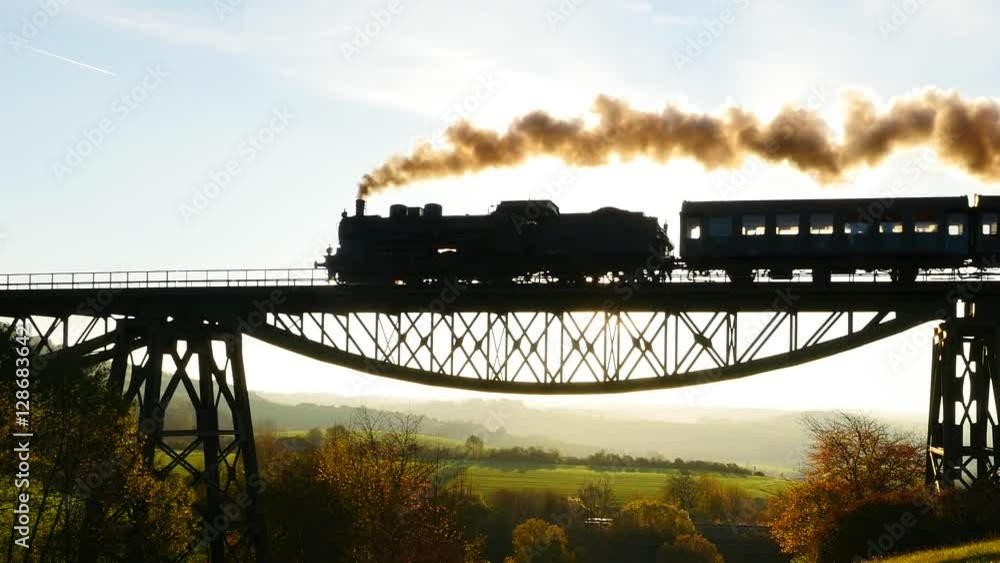 beautiful nostalgic view of steam locomotive train silhouette at sunset ...