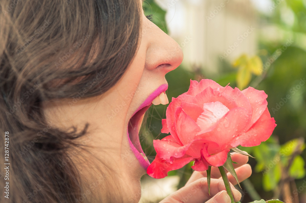 Woman biting a rose flower. Stock-Foto | Adobe Stock