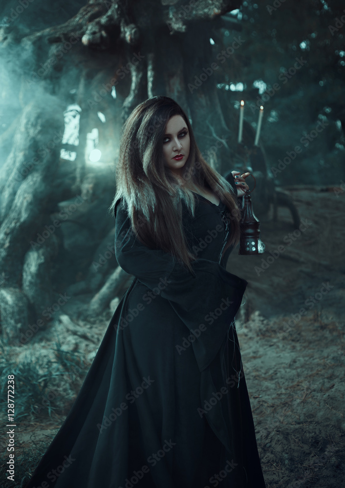 Dark witch casts a spell. In the background, mystical atmosphere ...