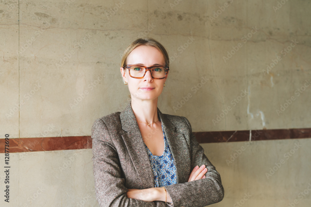 Portrait of yong 35 year old woman wearing brown eyeglasses and jacket ...