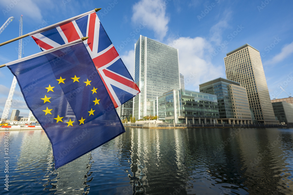 European Union and Union Jack flags flying above reflections of modern ...