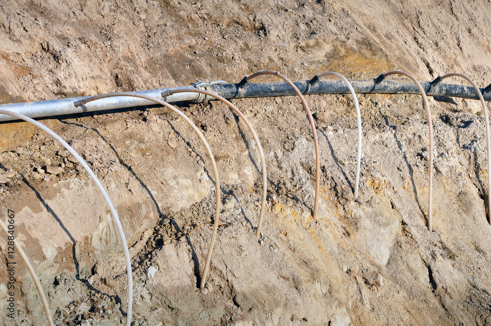 The process of lowering the groundwater level. Metal pipe with thin ...