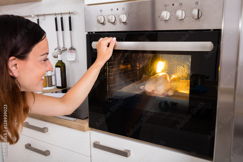 Woman Roasting Chicken Meat In Oven Stock Photo | Adobe Stock